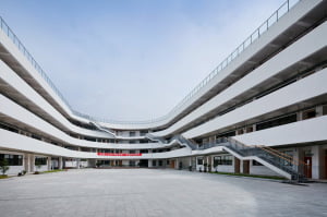 Rooftop running track shapes modern school building design - Kadva Corp